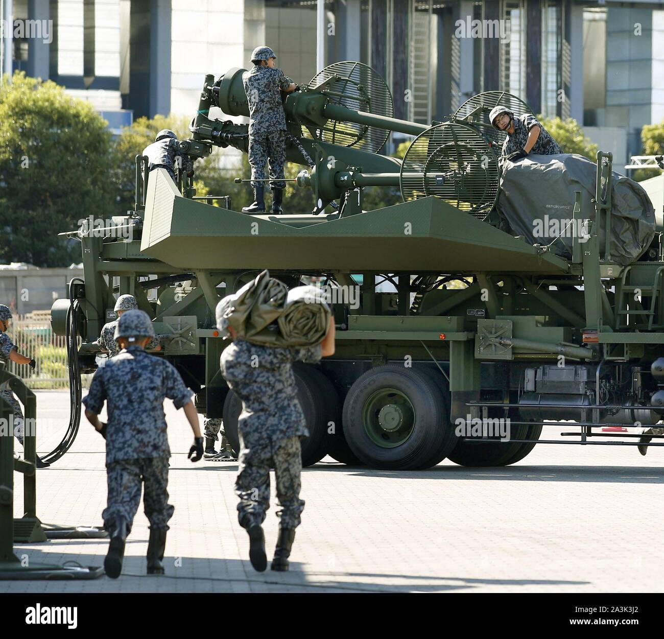 Japanese Air Self-Defense Force personnel install a missile interceptor ...