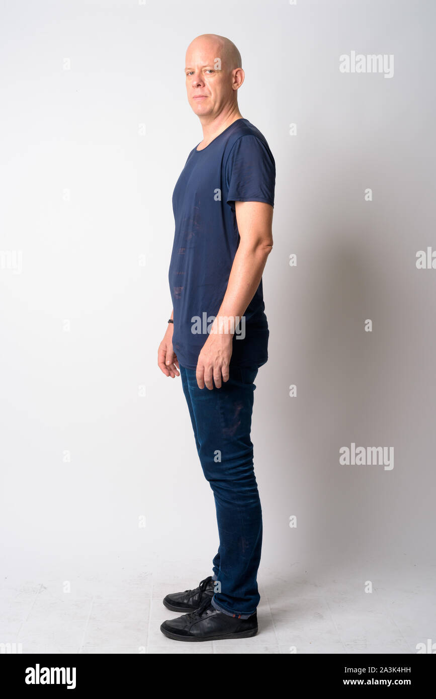 Full body shot profile view of mature handsome bald man looking at ...