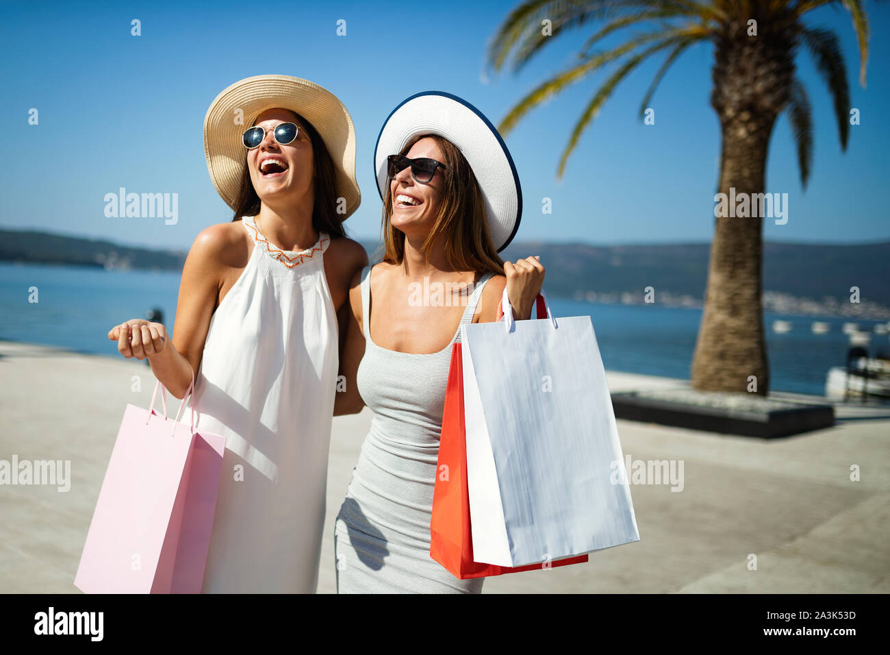 Shopping women happy holding shopping bags walking having fun laughing ...