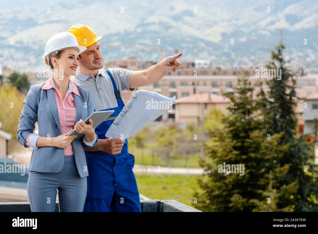 Property developer and construction worker creating project together ...