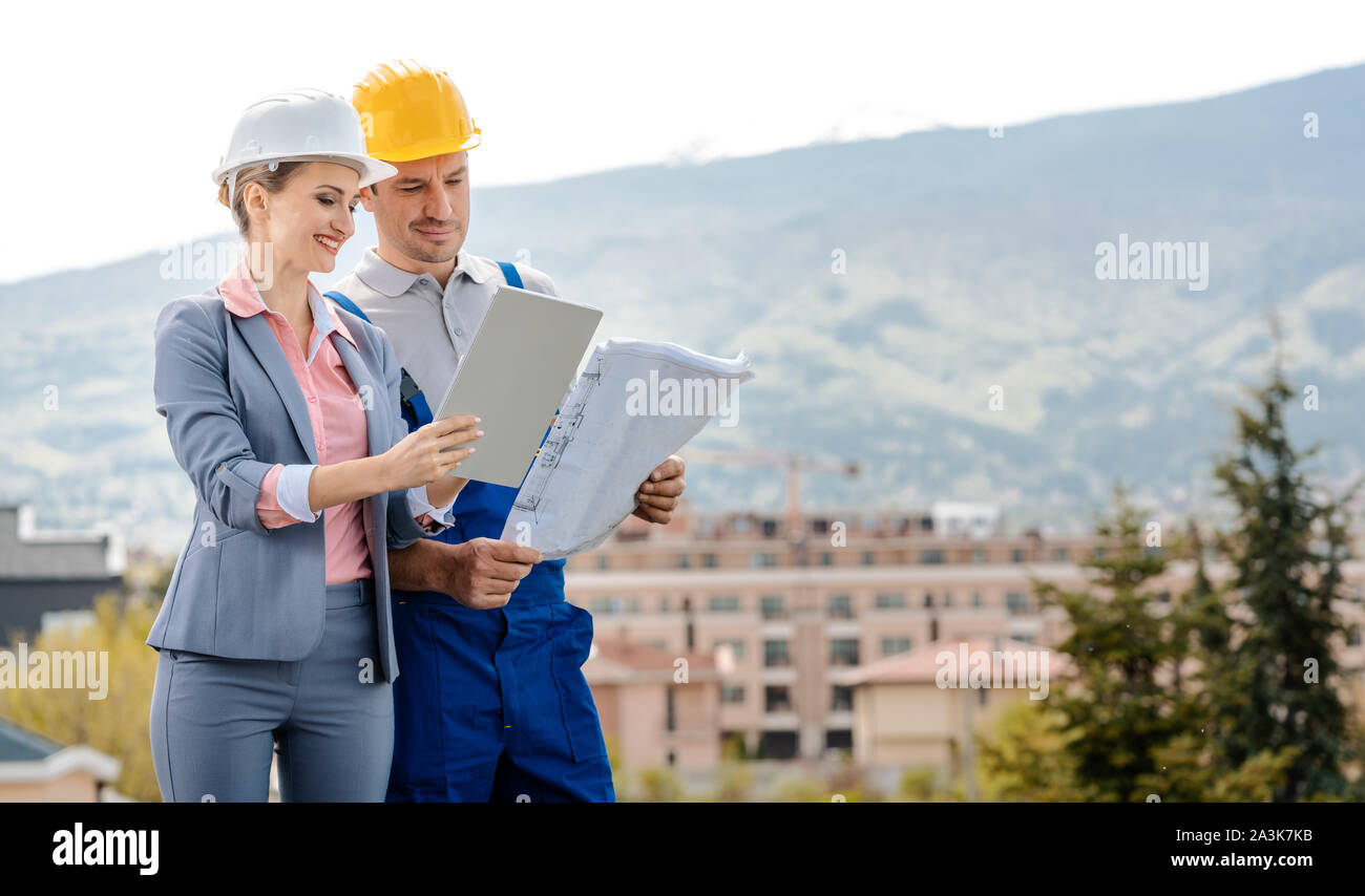 Property developer and construction worker creating project together ...