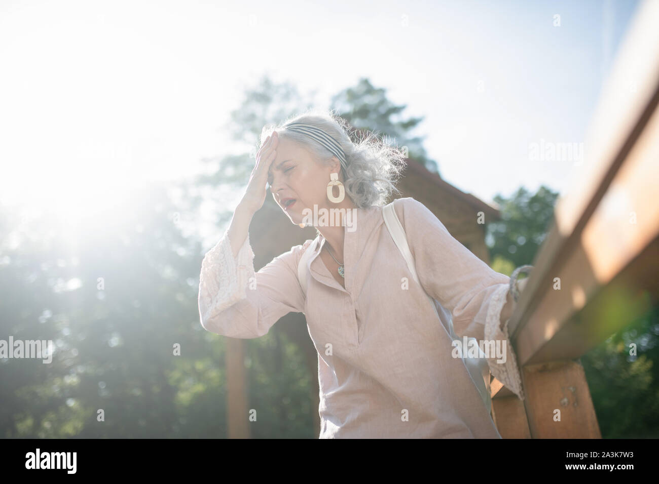 Low angle of woman feeling awful suffering from headache Stock Photo ...
