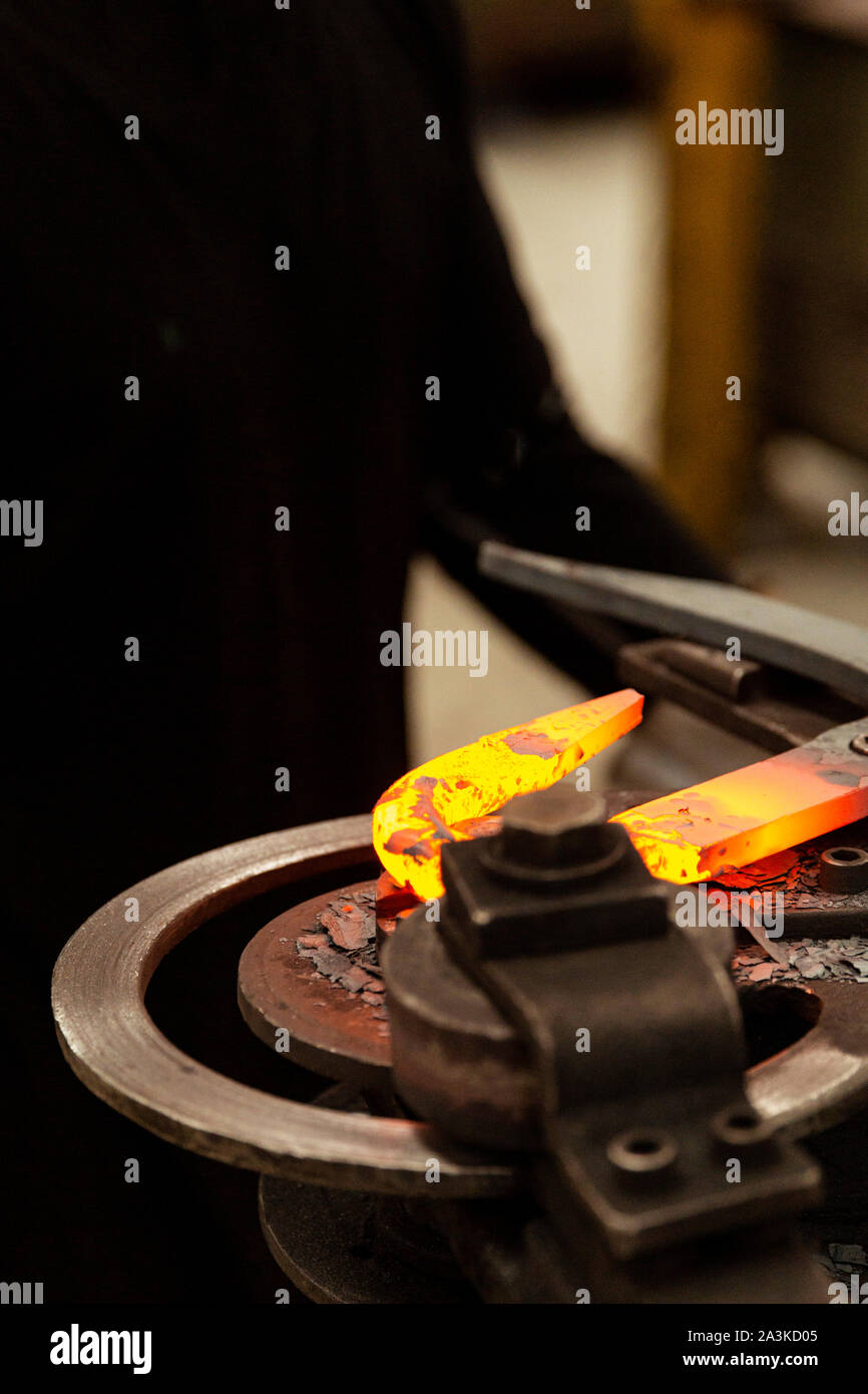 Hot metal bar bent into place ready for cooling Stock Photo - Alamy