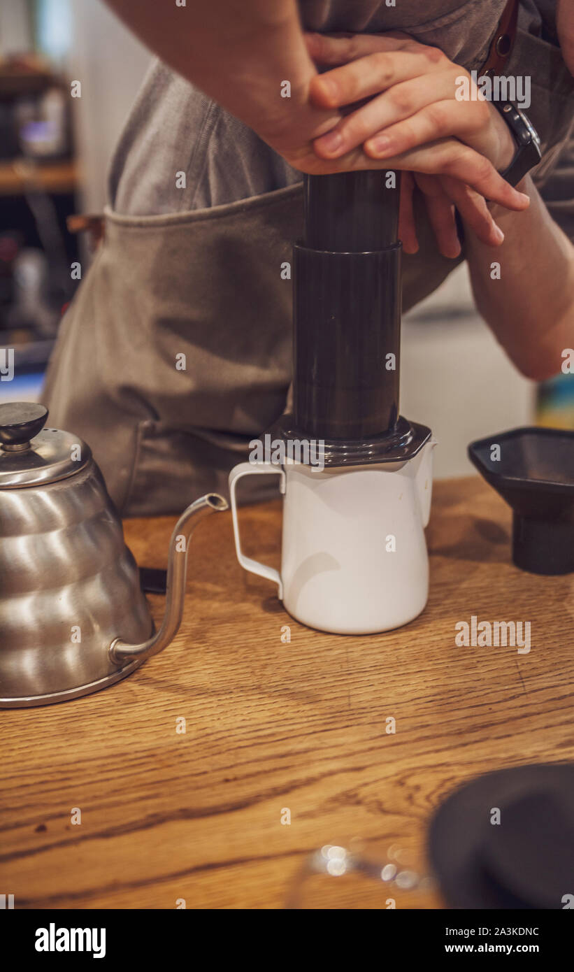Barista pushing coffee in an aeropress. Alternative method Stock Photo - Alamy