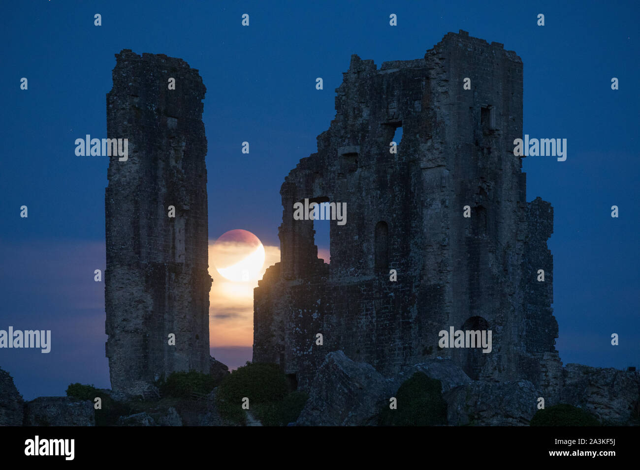 The partially eclipsed moon over Corfe Castle, Dorset, England, UK ...