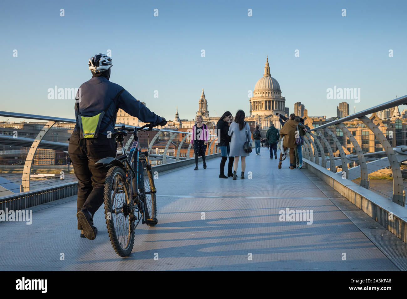 Pedestrians walking over the Millenium Bridge with St Paul's Cathedral ...