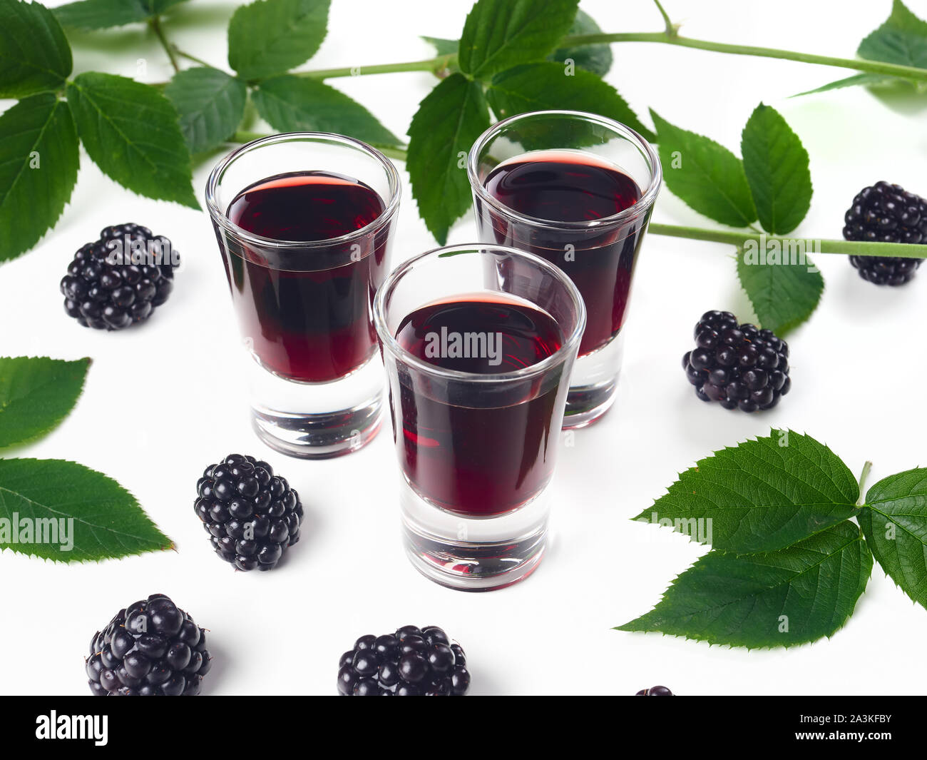Three glasses of blackberry liqueur, also known as creme de mure, on ...