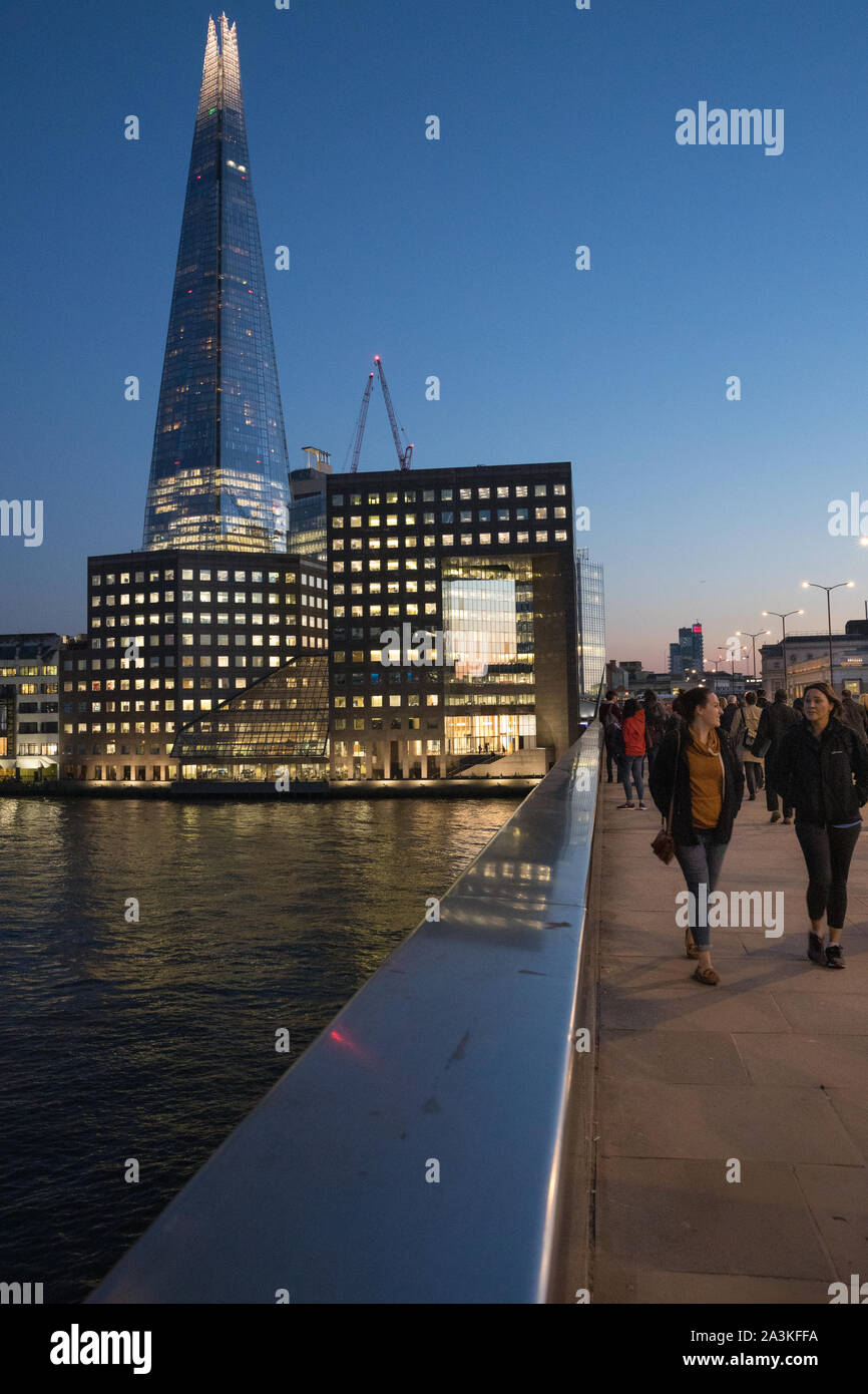 Commuters on London Bridge at dusk, with The Shard beyond, London ...