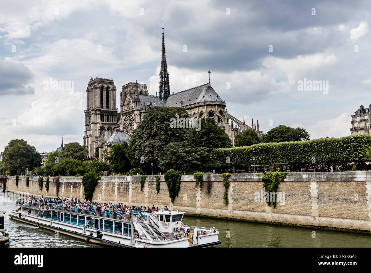 A cruise ship on the Seine and the Notre-Dame-de-Paris Cathedral Stock ...