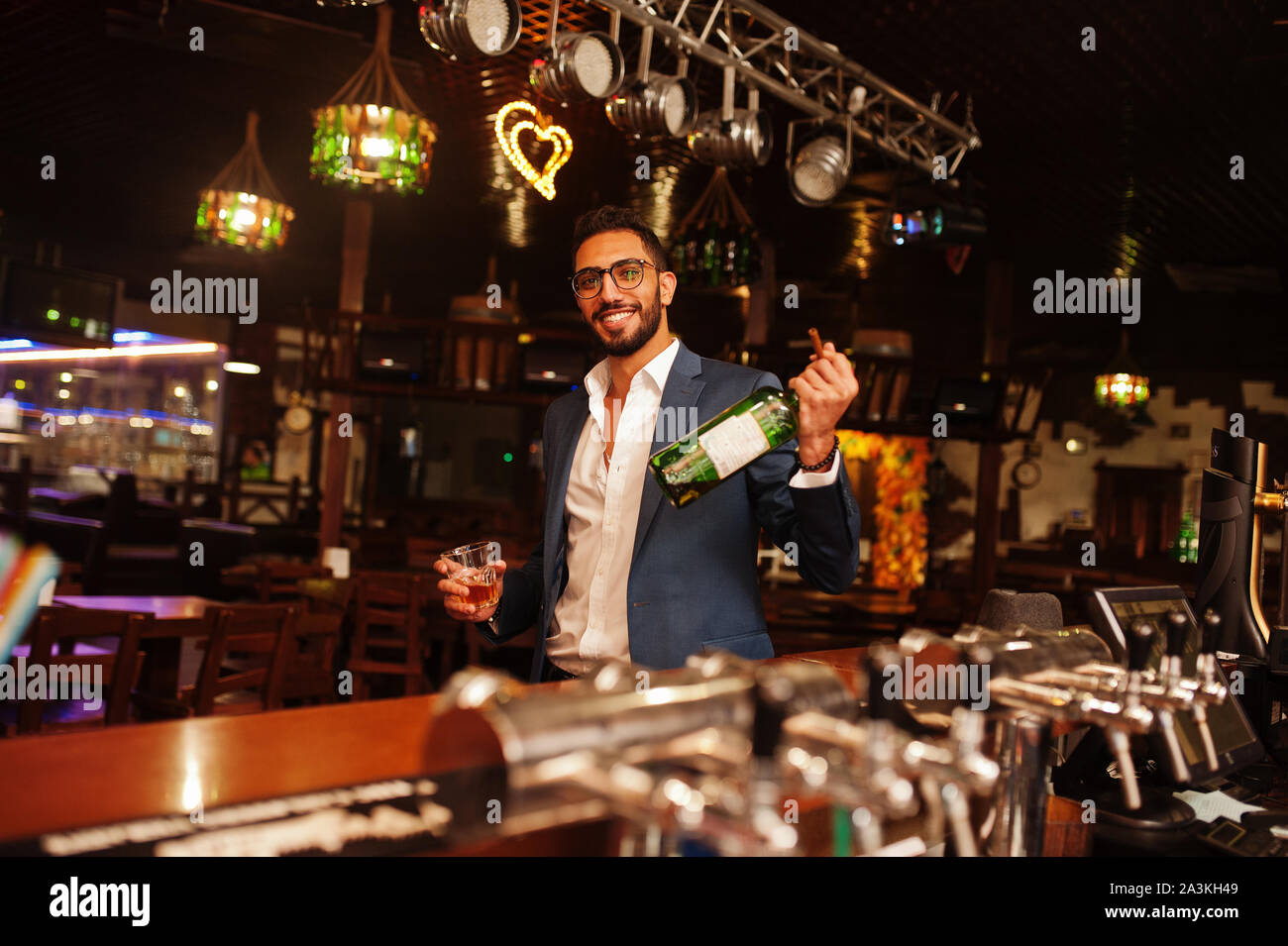 Handsome well-dressed arabian man with glass of whiskey and cigar posed ...