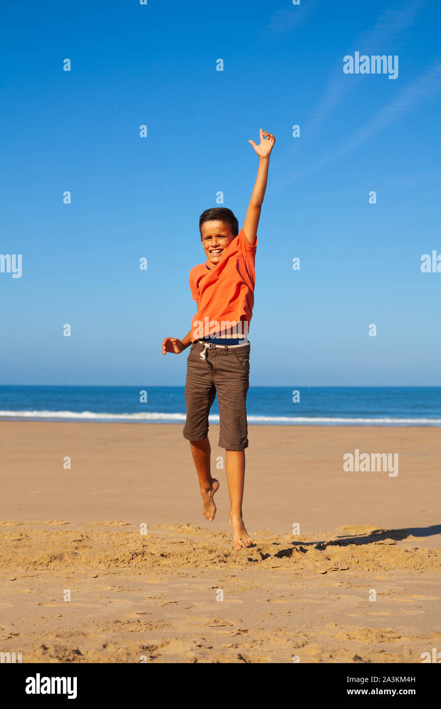 Handsome boy in red shirt jump lifting hand Stock Photo - Alamy