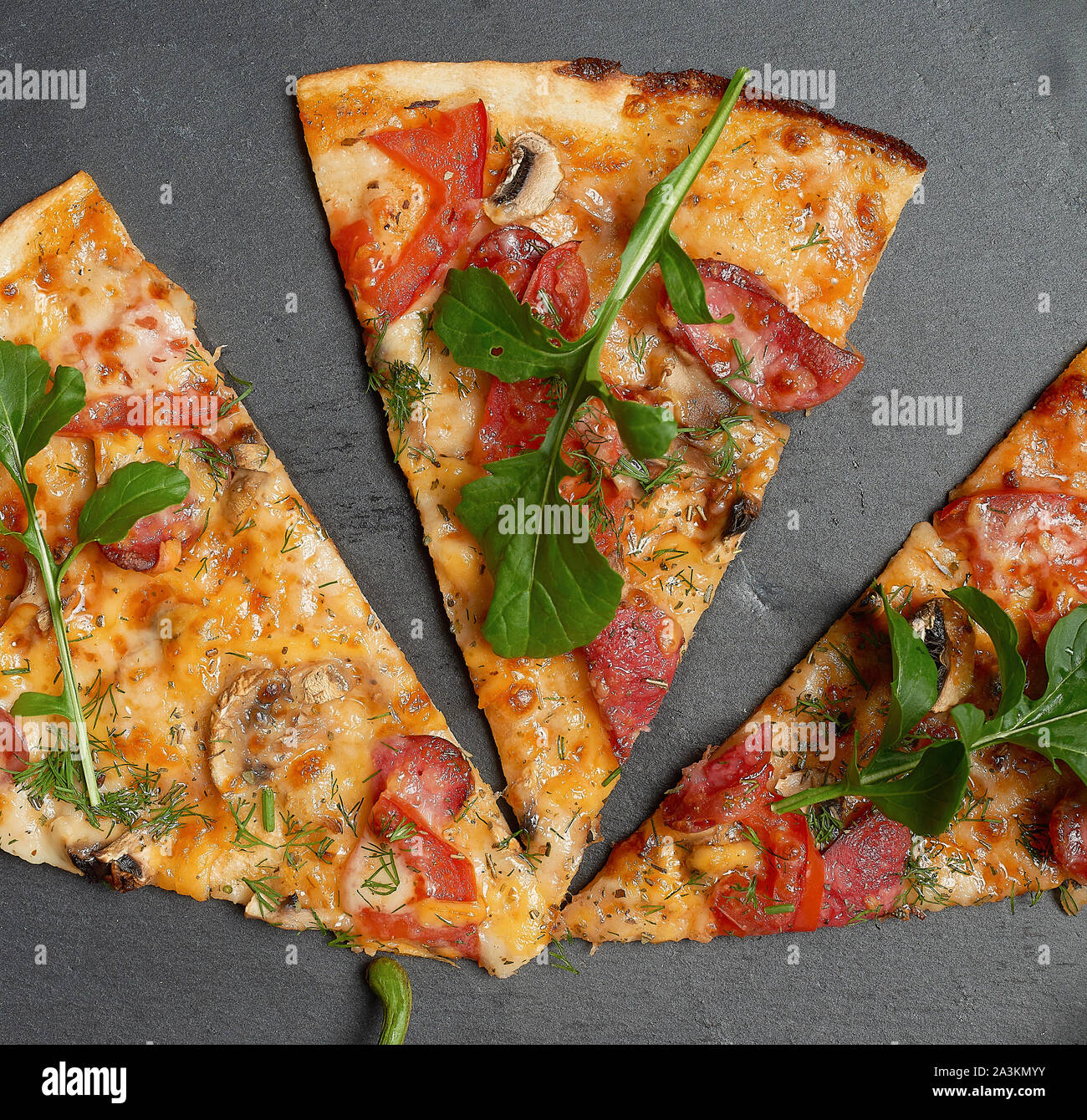 baked round pizza with smoked sausages, mushrooms, tomatoes, cheese and ...
