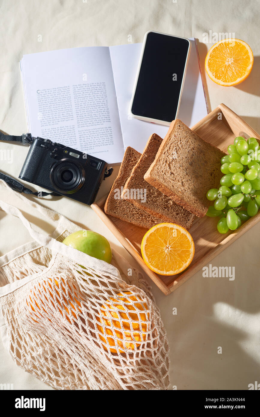 Phone, camera, fruit, bag, notebook and accessories, top view, Flat lay ...