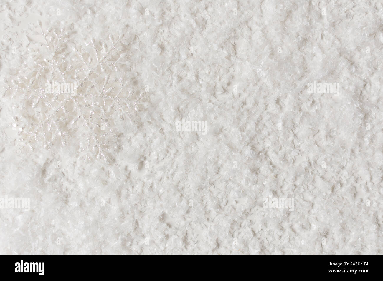 Snowflake in white artificial snow background top view. Christmas ...