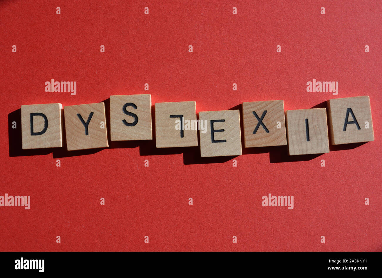 Dyslexia in 3d wooden letters, with the letter l upside down, on a red ...
