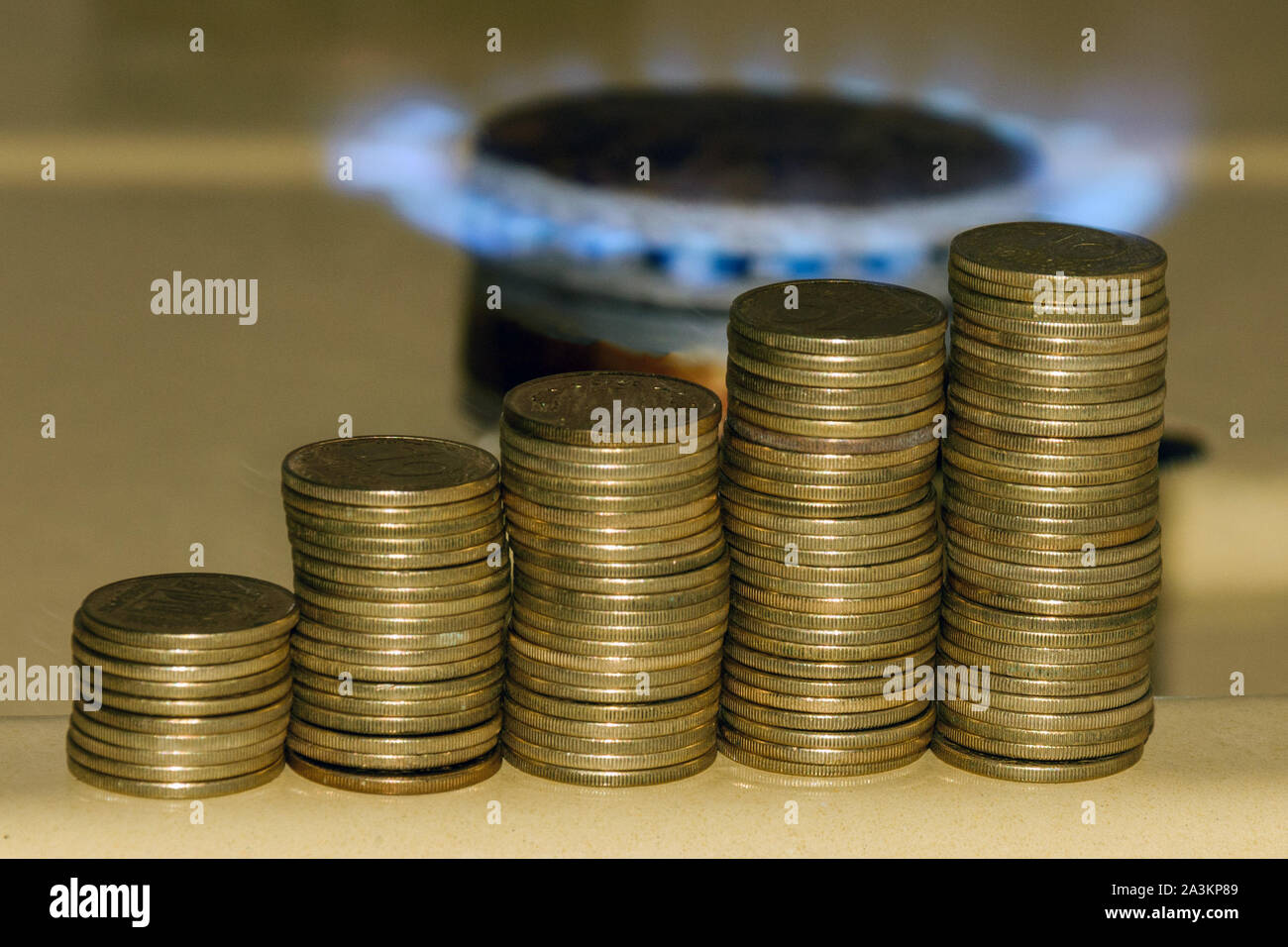 Increase in gas price concept. Blue gas flame and increasing stack of ...