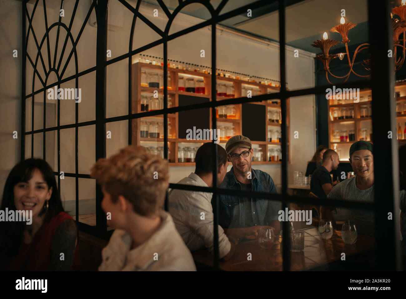 Young people talking over drinks at a bar at night Stock Photo - Alamy