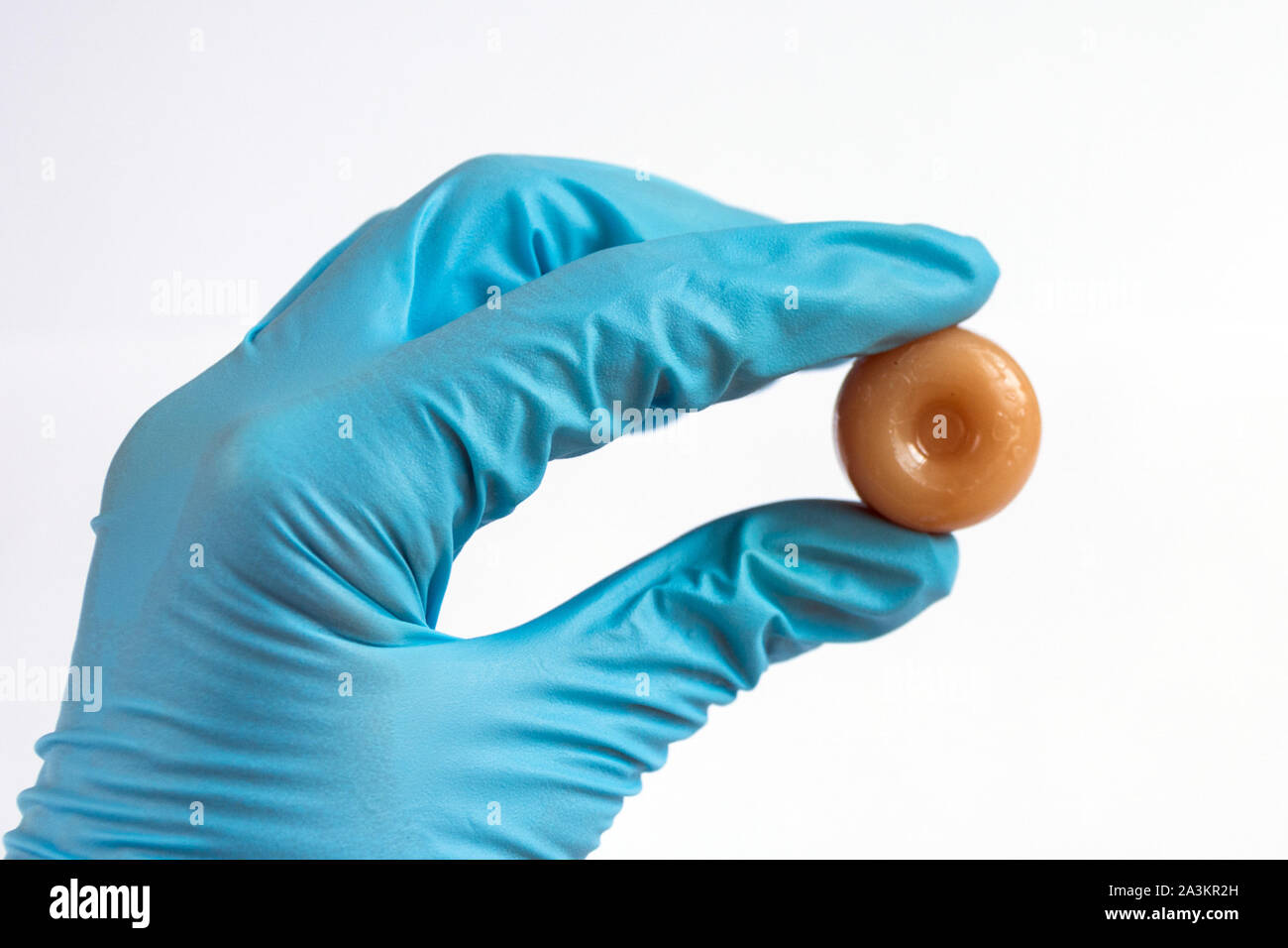 Doctor's hand is holding sweet candy pill on the white background ...