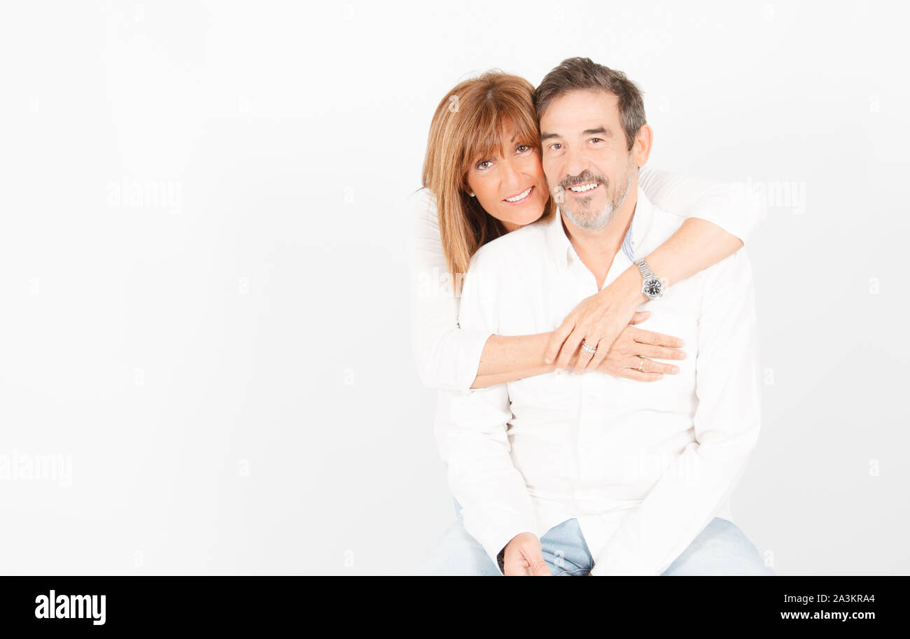 A 50-year-old adult couple poses in a photographic studio in a cheerful ...