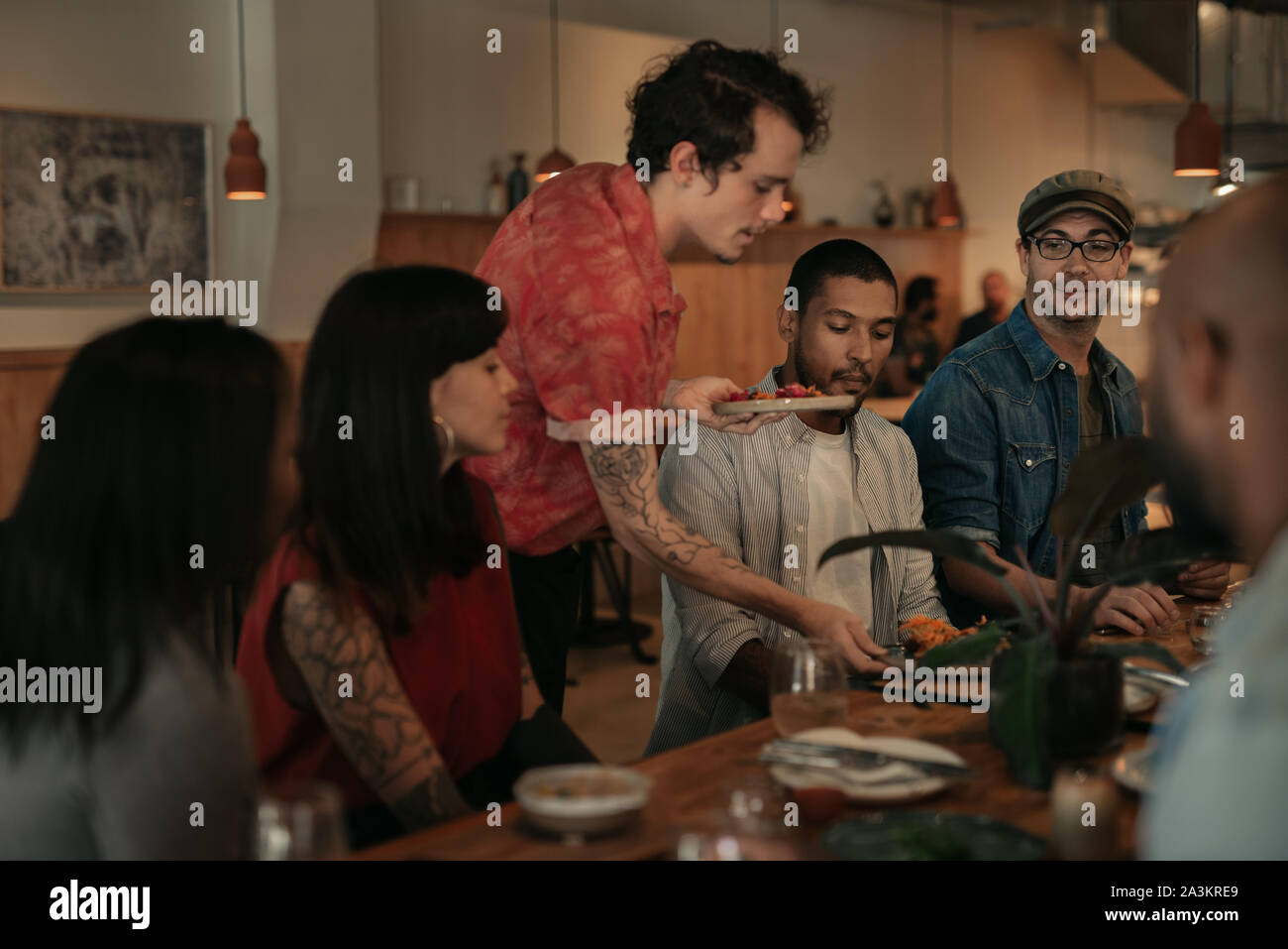 Waiter delivering food orders to a table of smiling customers Stock ...