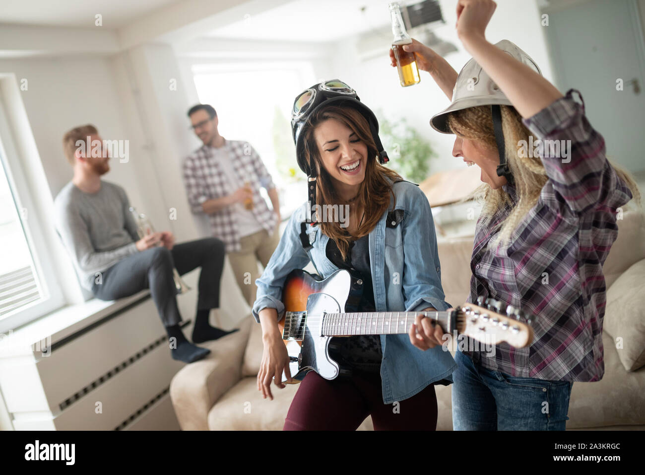 Cheerful friends having party together and playing instruments Stock ...