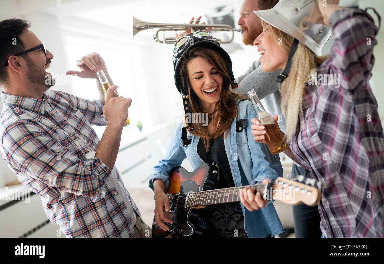Cheerful friends having party together and playing instruments Stock ...