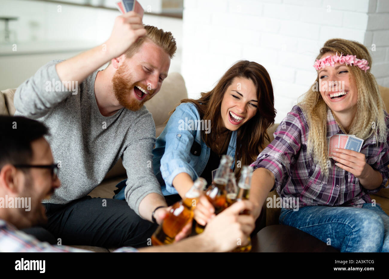 Group of friends relaxing and playing cards together. Young people ...