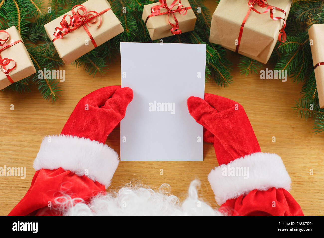 Close-up of Christmas letter in Santa Claus hands with gift boxes and ...