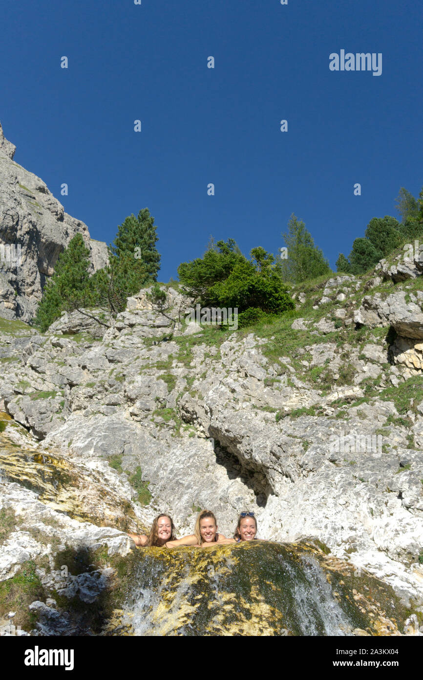 three attractive young women go for a bath in a cold mountain stream in ...