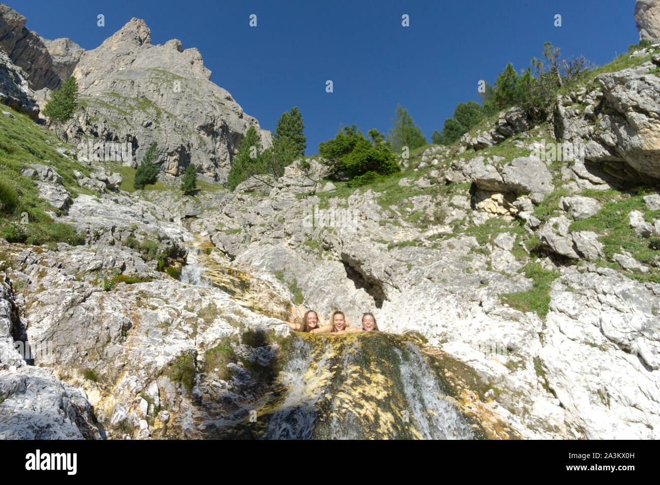 three attractive young women go for a bath in a cold mountain stream in ...