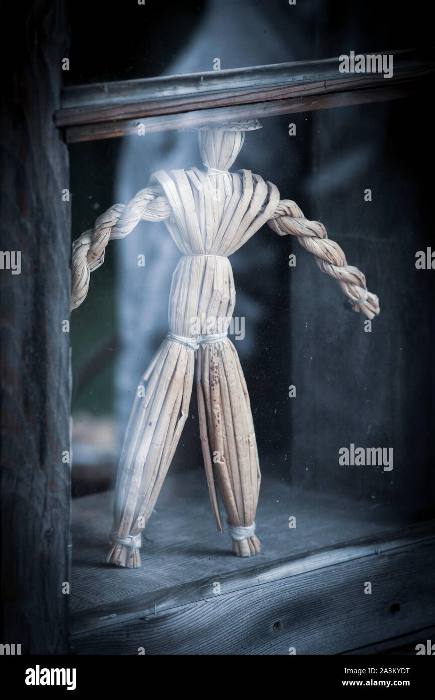 Straw man figurine hand made crafted behind the window on windowsill in ...