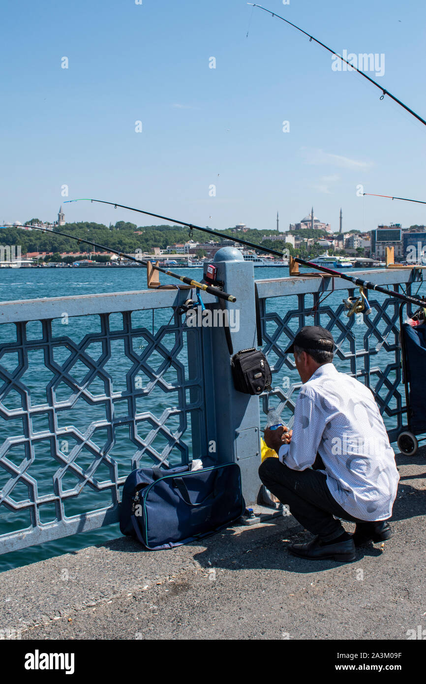 Istanbul: skyline of the city and local fishermen with their fishing ...