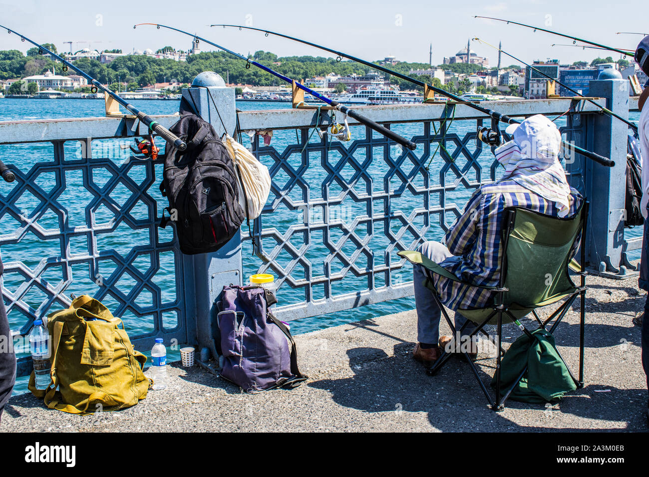 Istanbul: skyline of the city and local fishermen with their fishing ...
