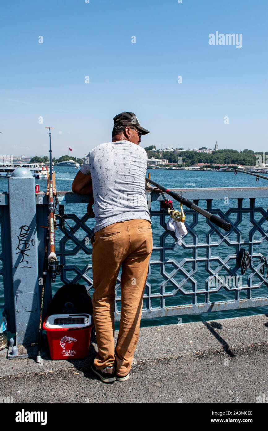 Istanbul: skyline of the city and local fishermen with their fishing ...
