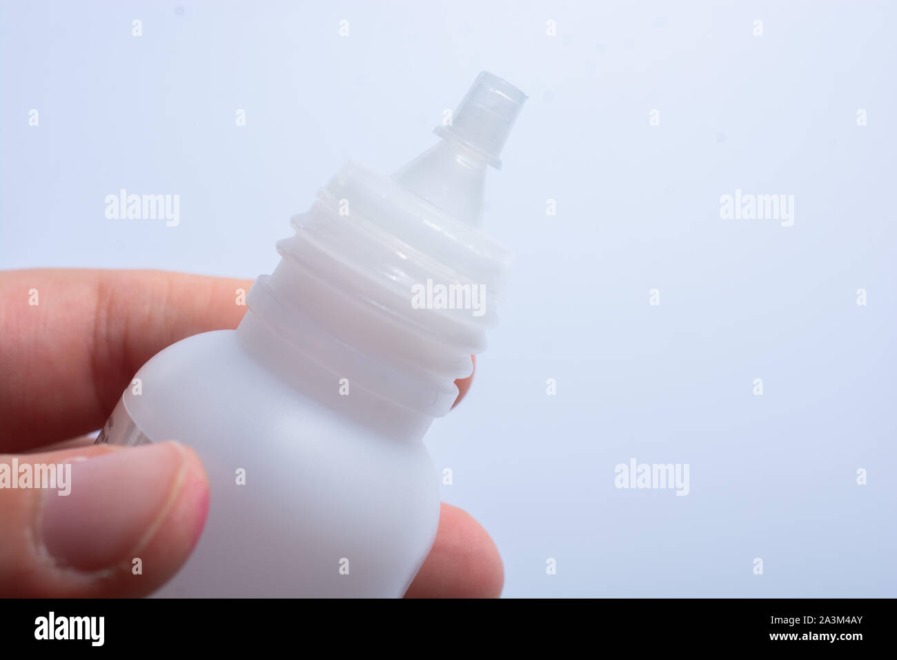 White empty dropper bottle in hand on a white background Stock Photo ...