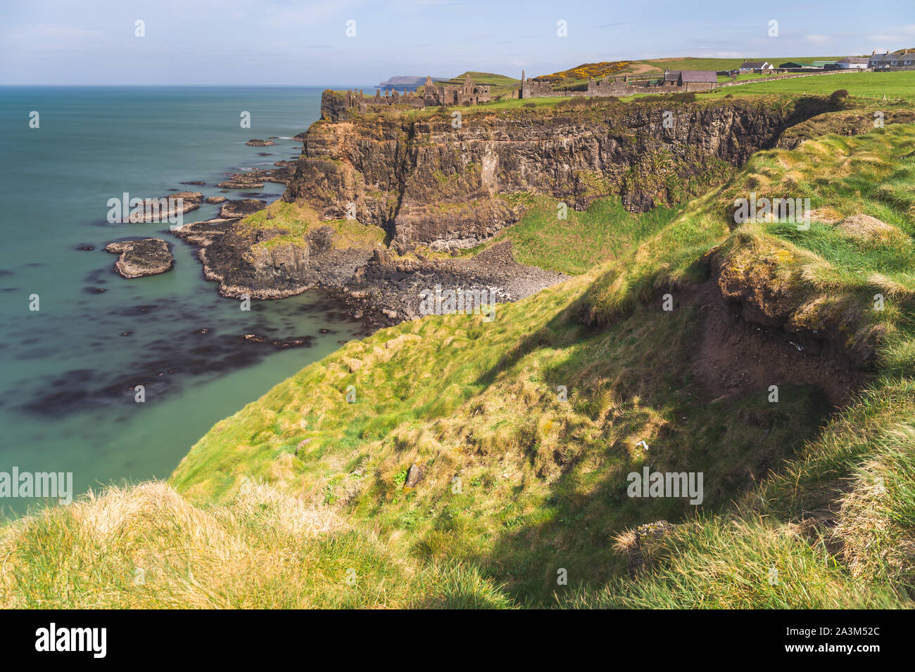 Early morning sunlight over Dunluce Castle at the Causeway Coast of ...
