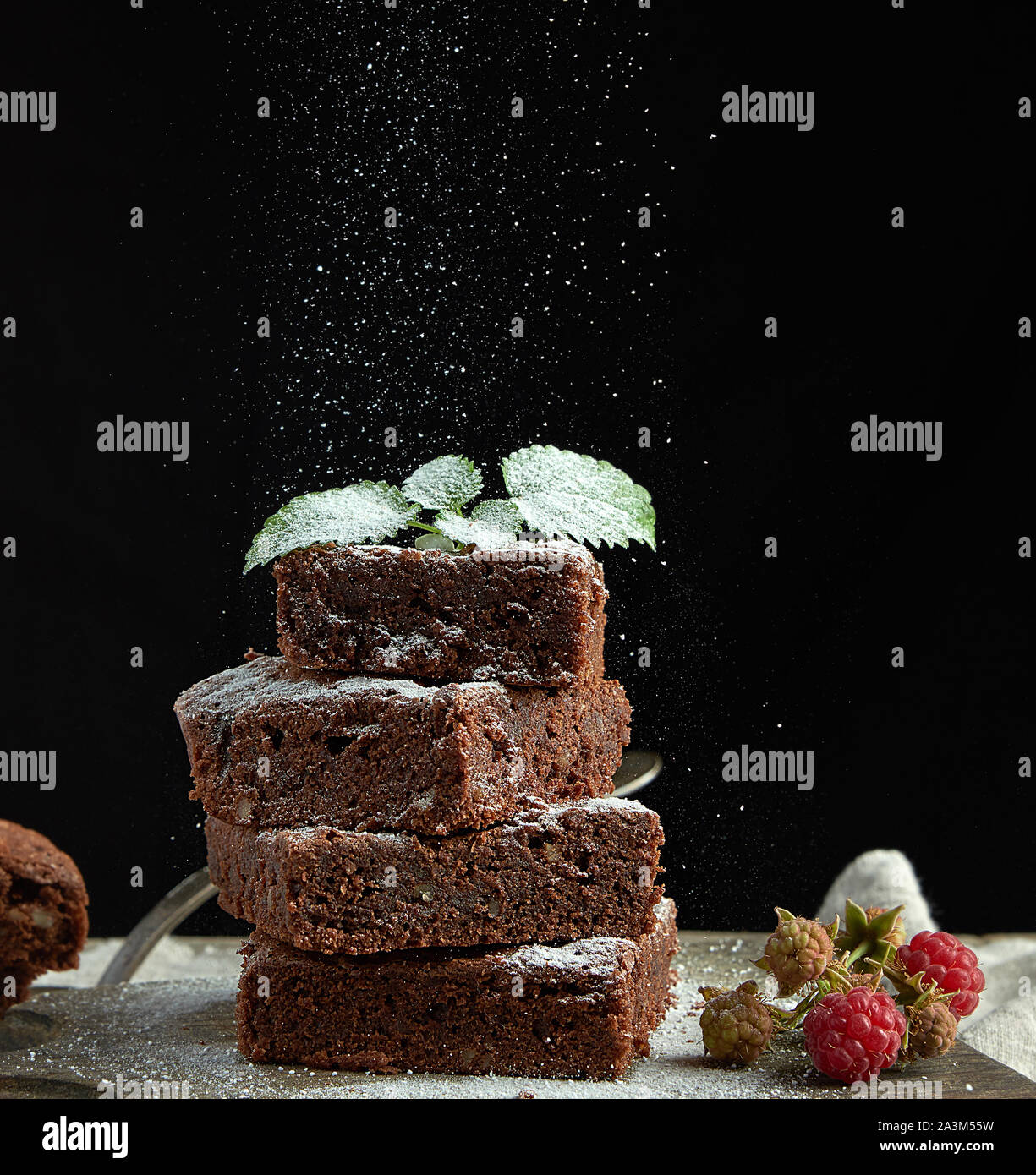 stack of square baked brownie chocolate cake slices sprinkled with ...