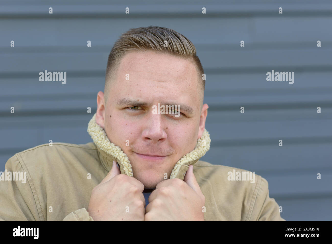 Cold young man shivering and snuggling into the collar of his warm ...