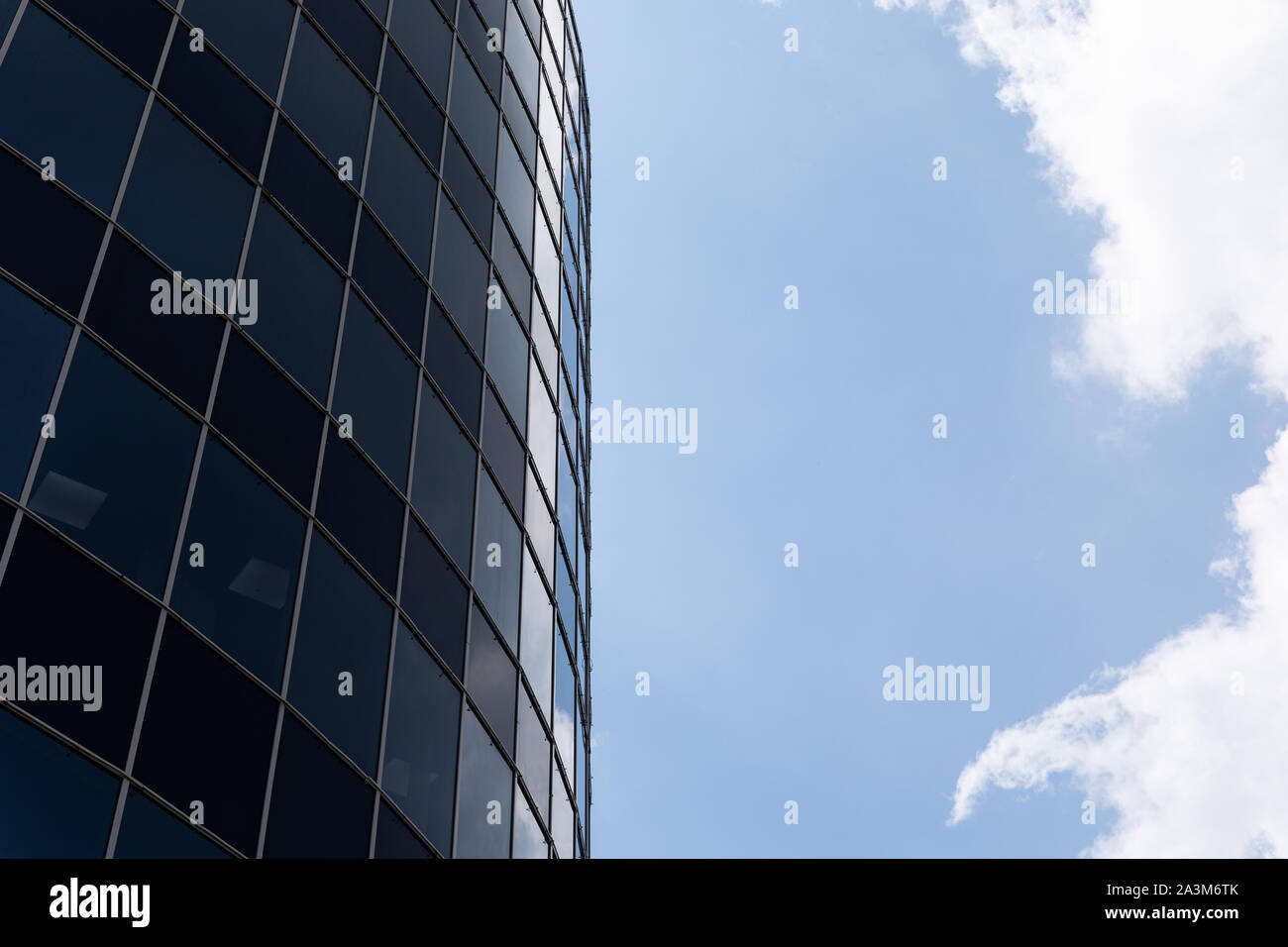 Side view of dark glass facade building in business city area with sky ...