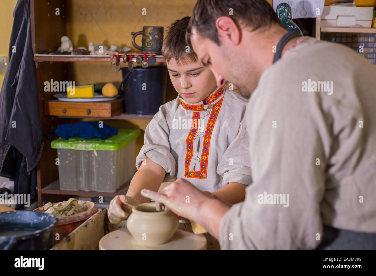 Potter showing how to work with ceramic in pottery studio Stock Photo ...