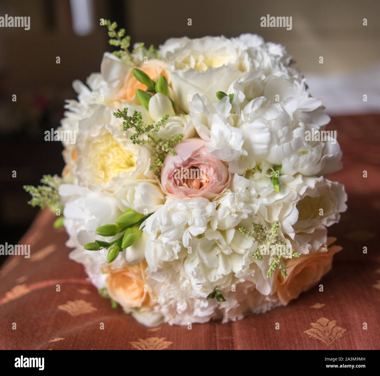 White bouquet of the bride with freesia, roses and peonies, lying on ...