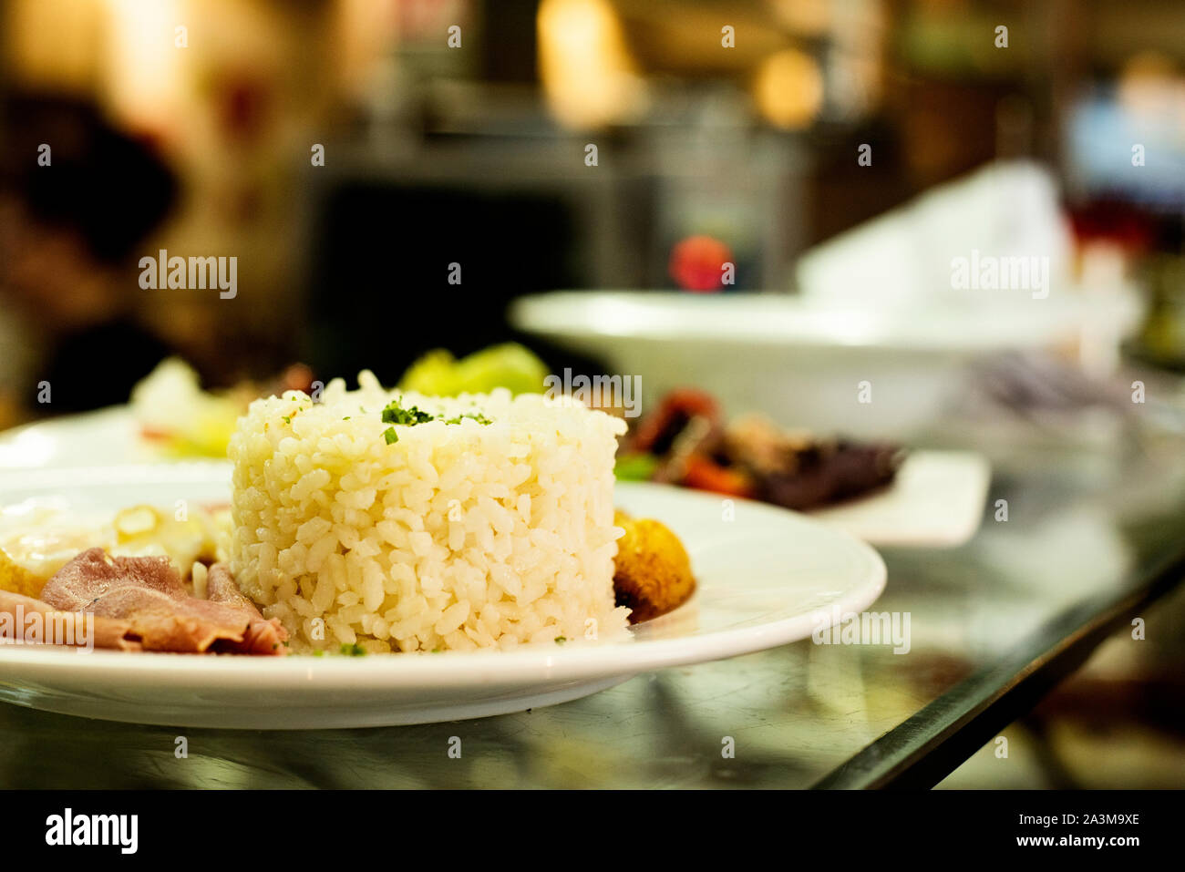 some plates in an open kitchen of a restaurant ready to be served, one ...