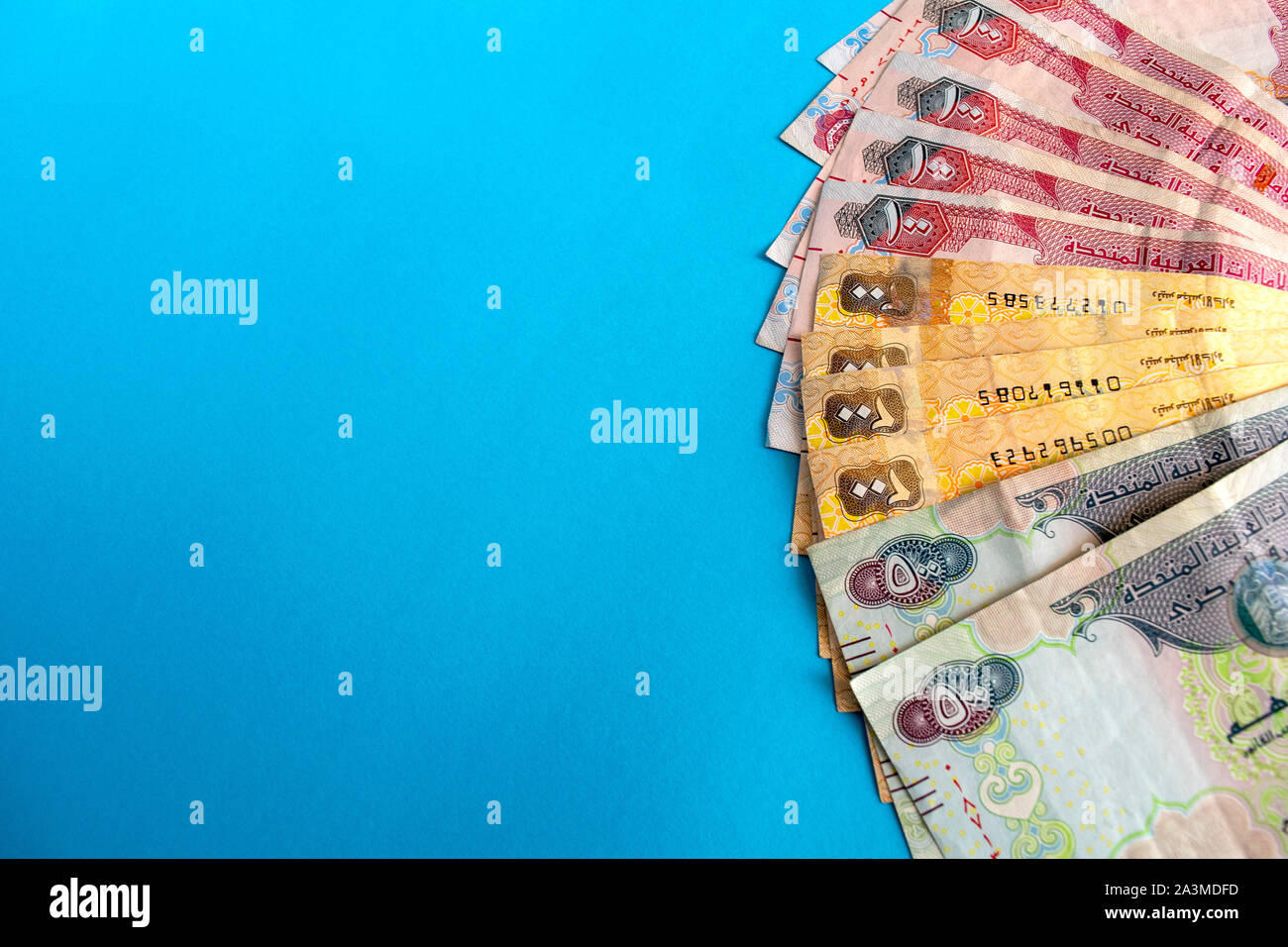 UAE national currency, dirhams banknotes. Money banknotes on blue ...