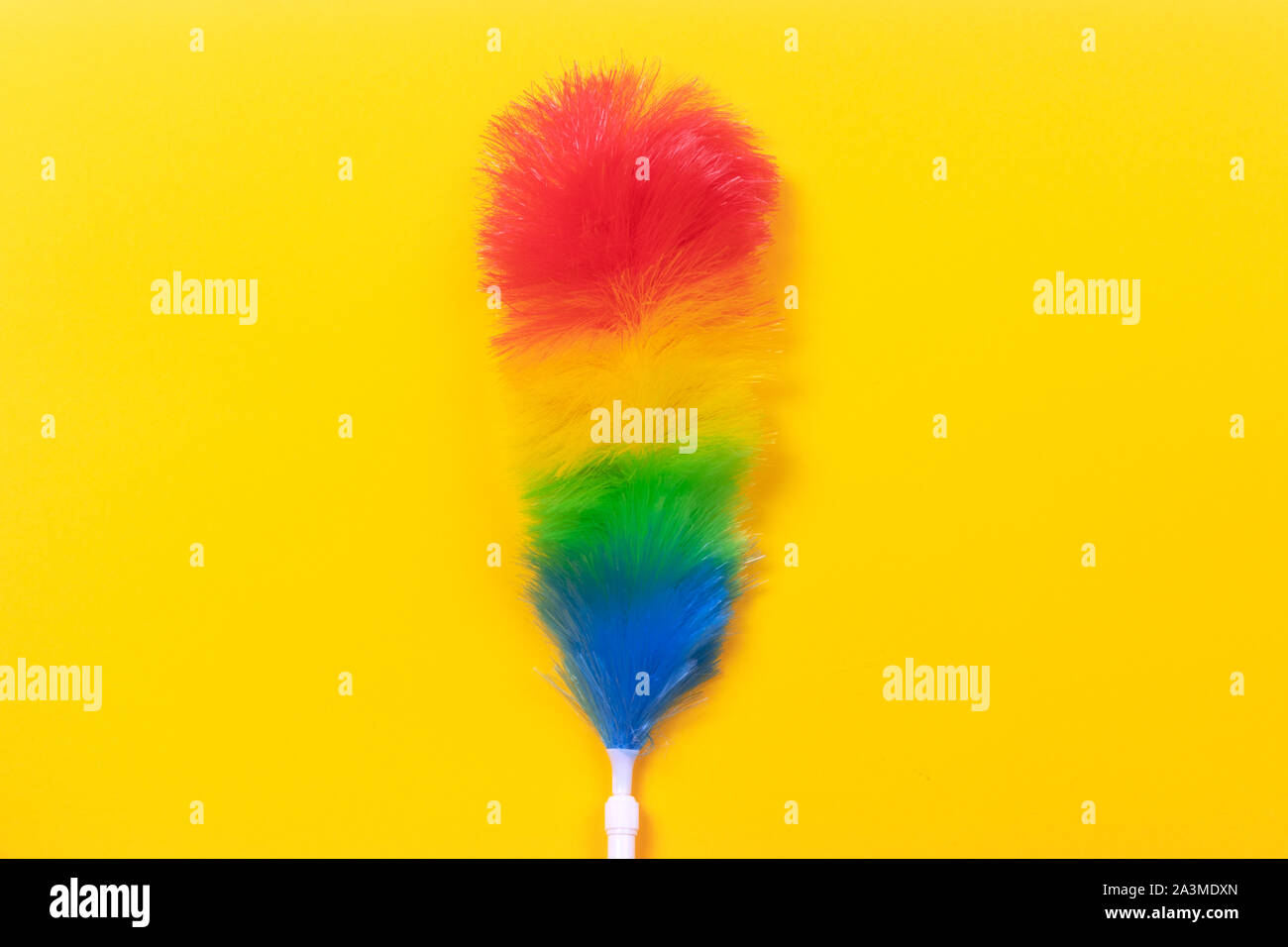 Colorful feather duster on yellow background. Cleaning concept Stock ...