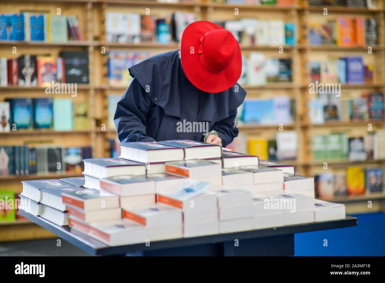 A woman in a red hat is is engrossed in a book at a bookstore during ...