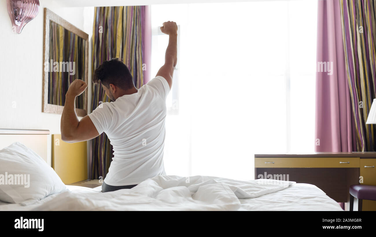 Man stretching after waking up in hotel room Stock Photo - Alamy