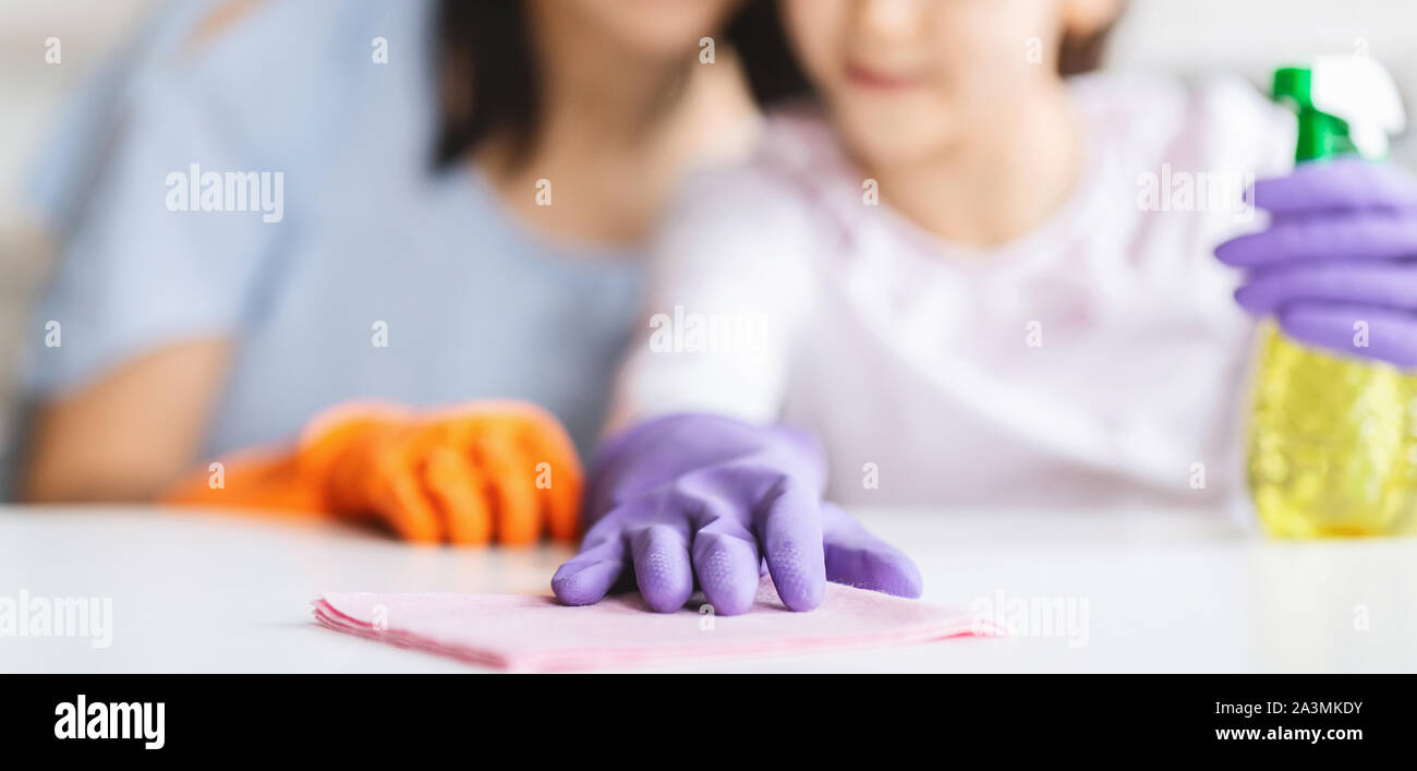 Little girl and her mom cleaning table surface from dust Stock Photo ...