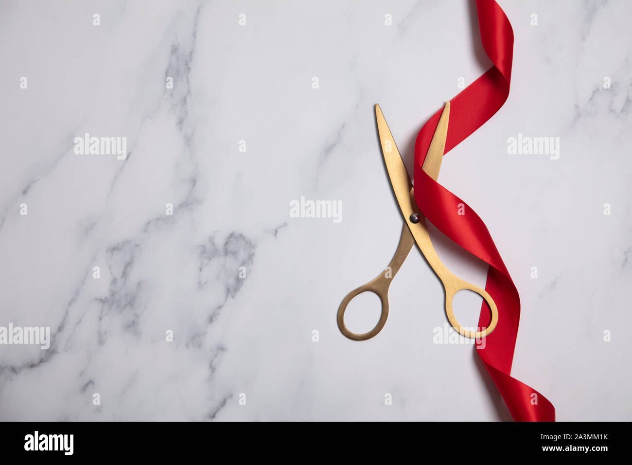 Grand opening background. Gold scissors with red ribbon on a marble ...