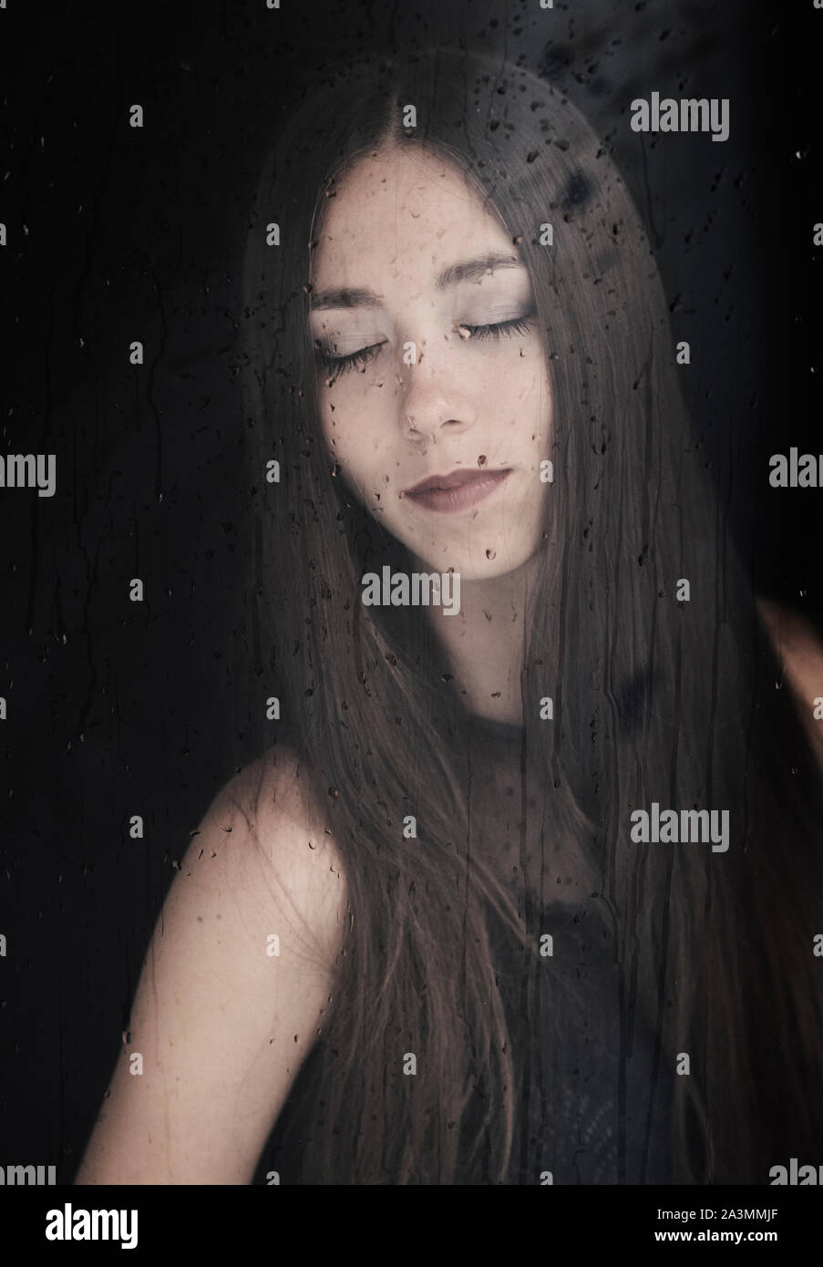 beautiful young woman behind wet window Stock Photo - Alamy