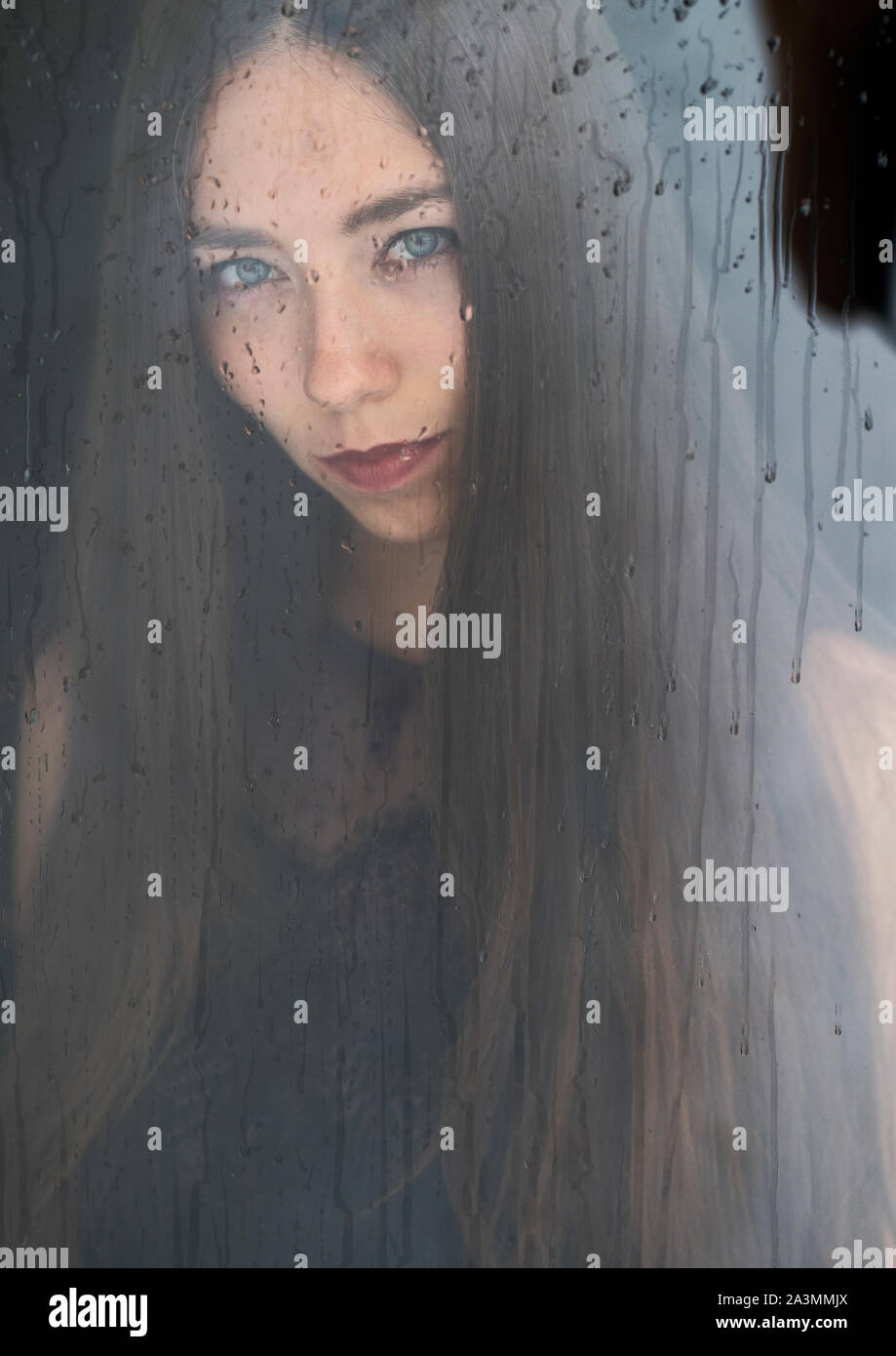Woman behind wet window hi-res stock photography and images - Alamy